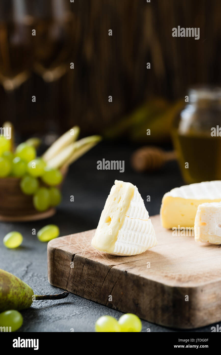French soft cheese from Normandy region sliced with green grapes, pear ...