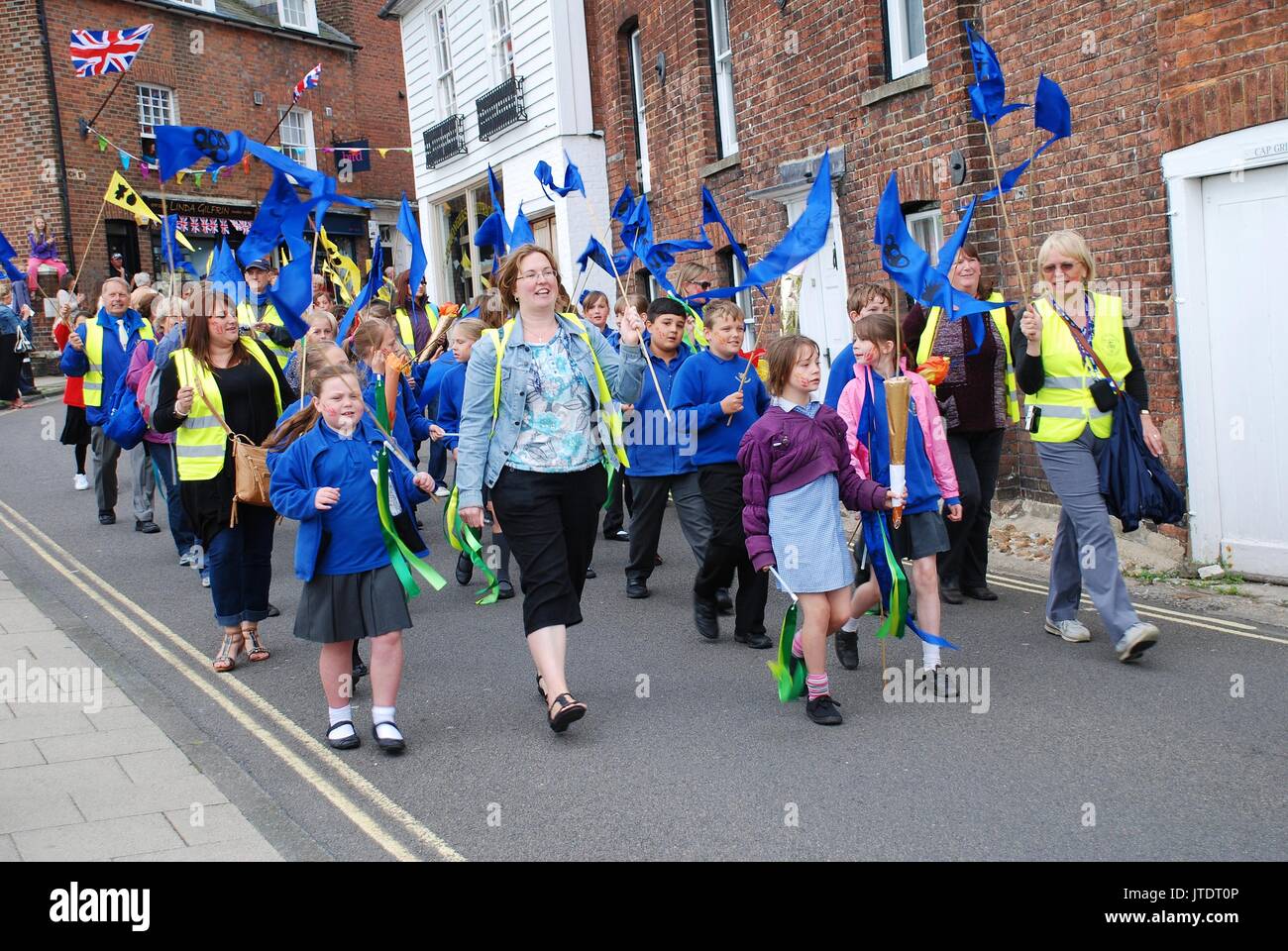 People parade through the streets at an Olympic torch relay event at ...