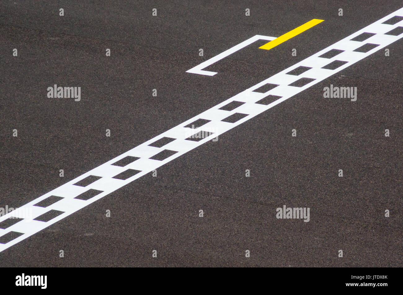 Minimalistic photo of a chequered finish line on a track. Signifies the ...