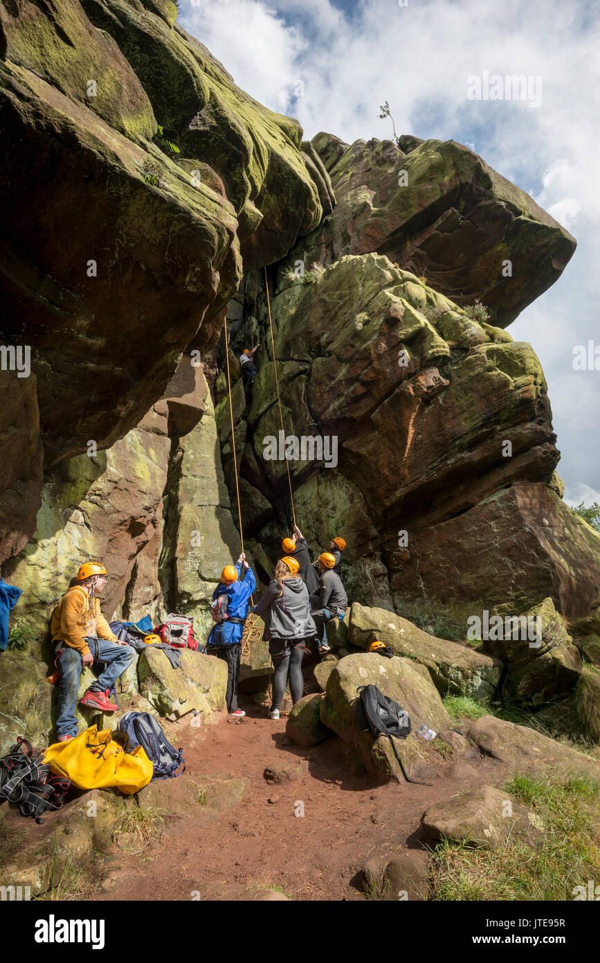 Group Of Young People Rock Climbing At The Roaches In The Peak District