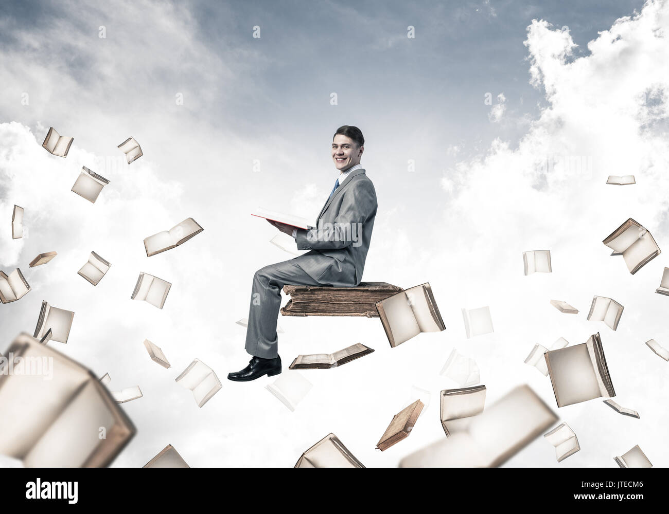 Man reading book and many of them flying in air Stock Photo - Alamy