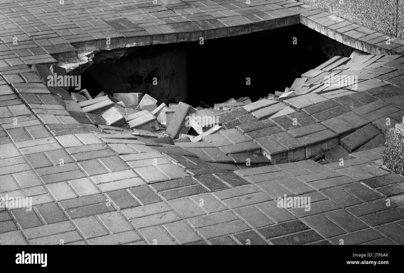 A hole in pedestrian pavement road Stock Photo - Alamy