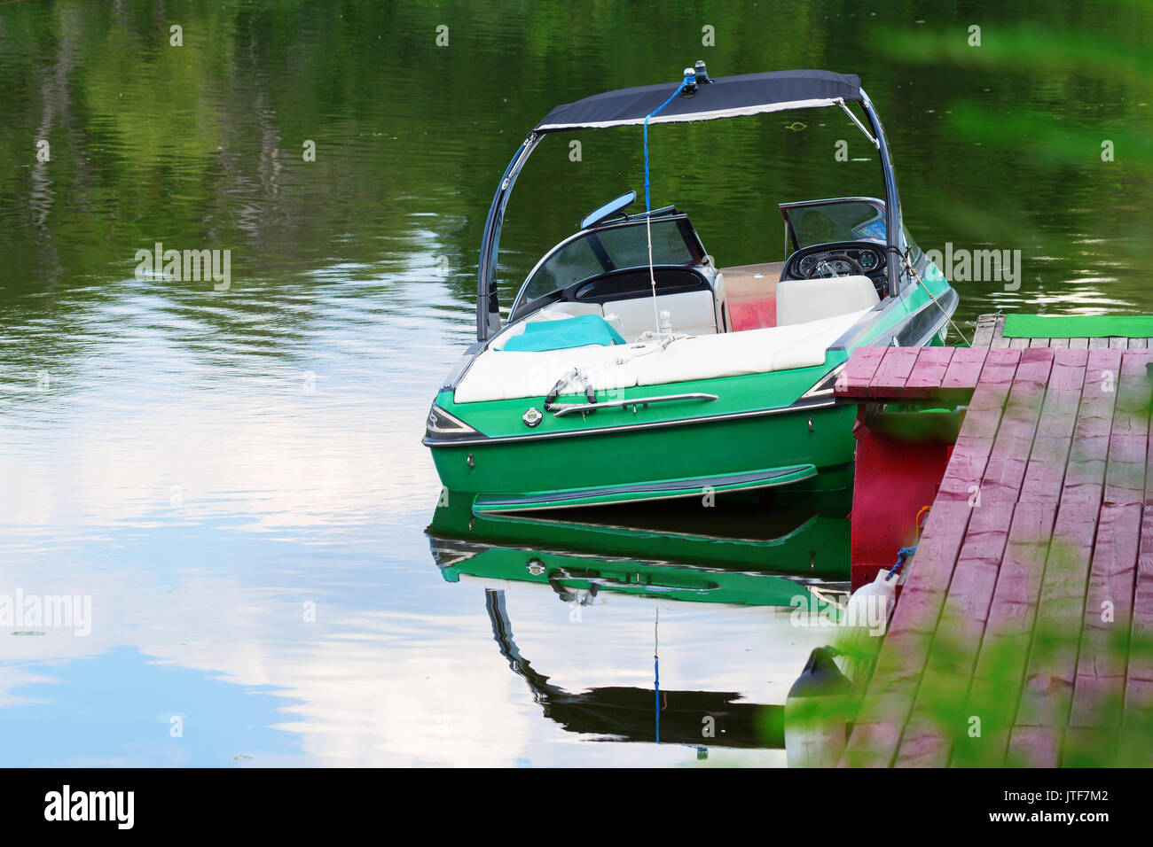 Motor boat moored by the pier in silent place with beautiful nature ...