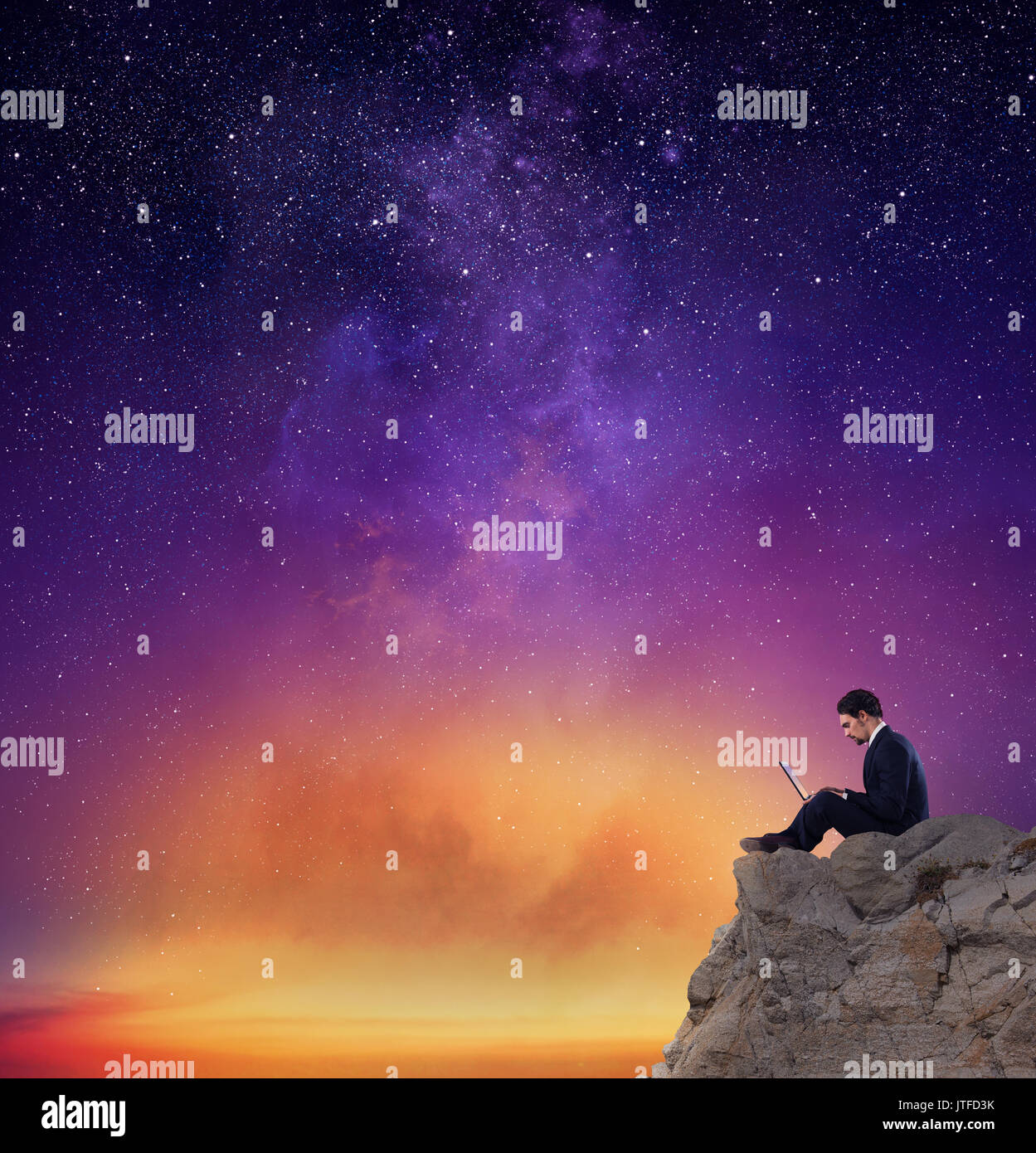 Businessman works on laptop with internet connection over a mountain ...