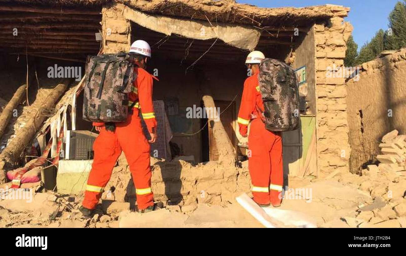 Jinghe. 9th Aug, 2017. Rescuers check a house damaged in earthquake in ...