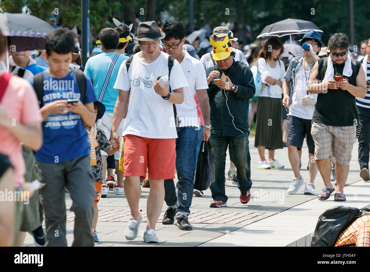 People catch Pokemon characters on their smartphones on one of the ...