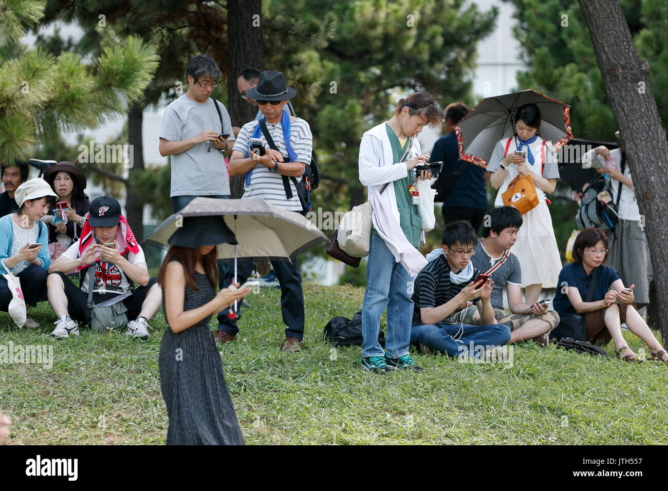 People catch Pokemon characters on their smartphones on one of the ...