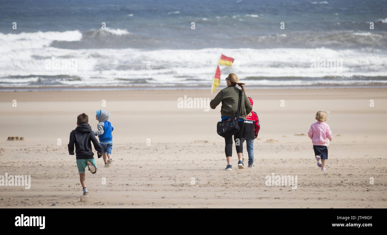Children running on beach on a windy day. Seaton Carew, County Durham ...