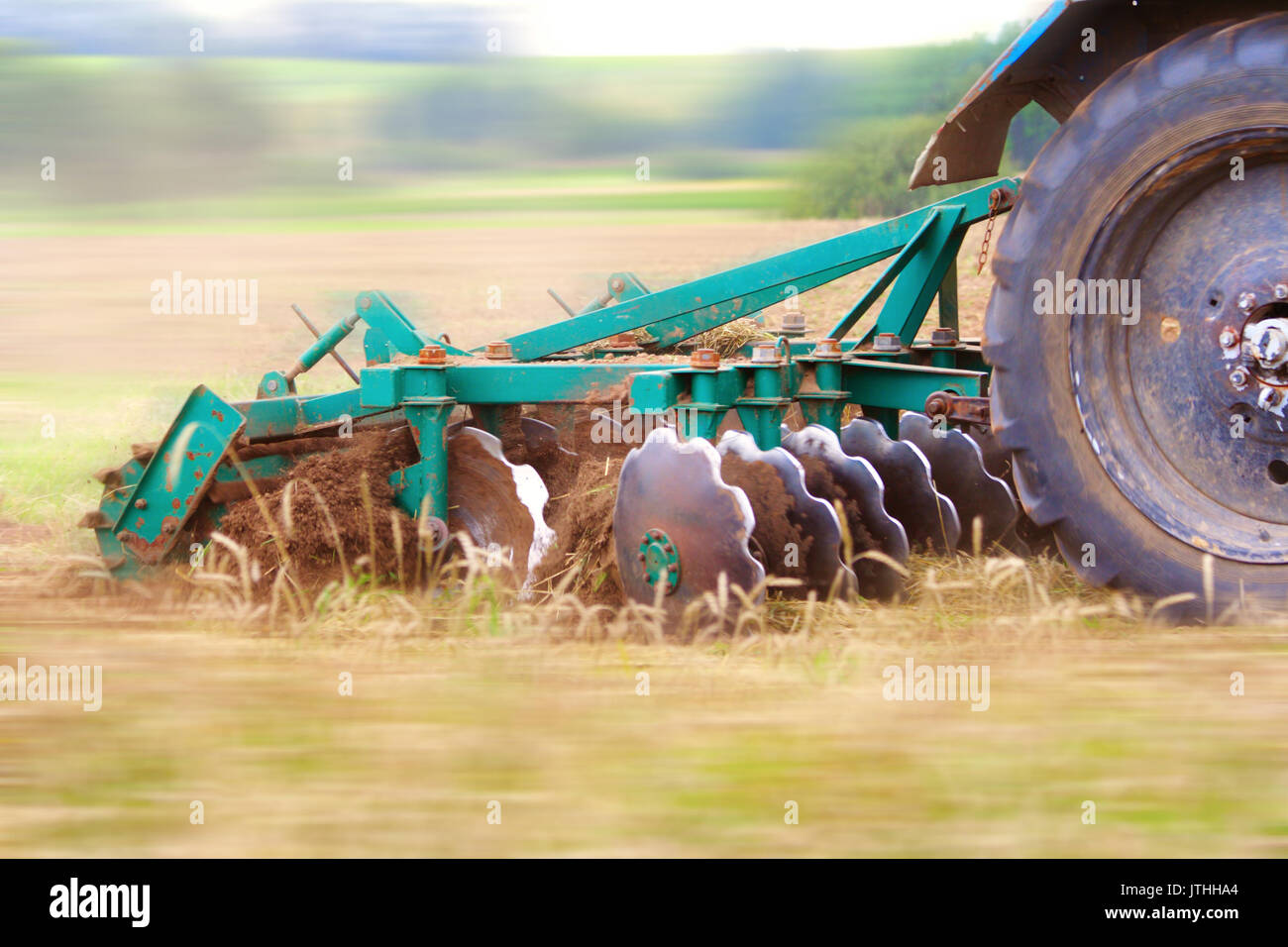 Tractor ploughing the field. Motion blur was done for effect to ...