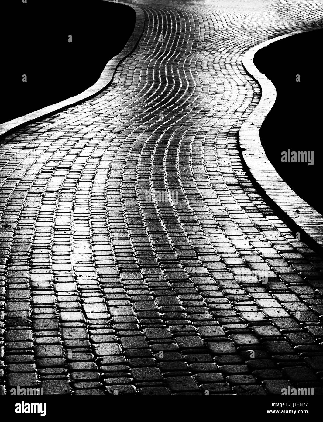 Silver paved path isolated on black Stock Photo - Alamy