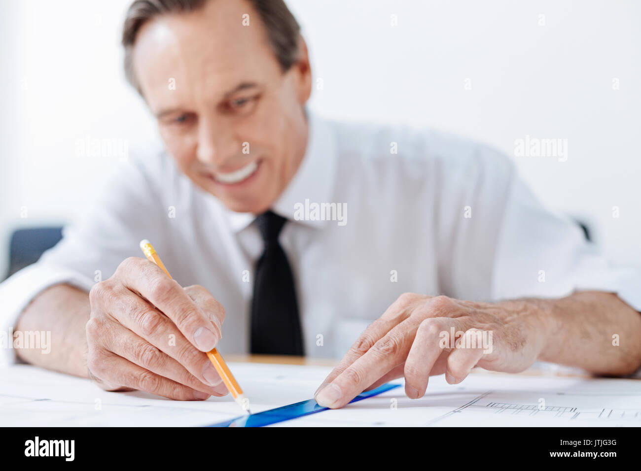 Senior engineer drawing a line with pencil and ruler Stock Photo - Alamy