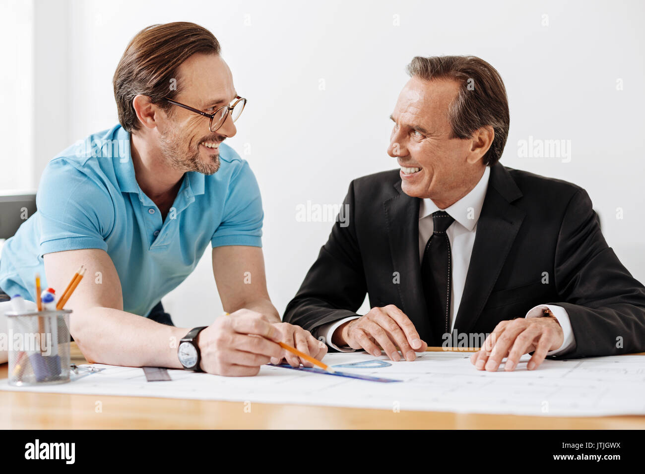 Engineers looking at each other while drawing a blueprint Stock Photo ...