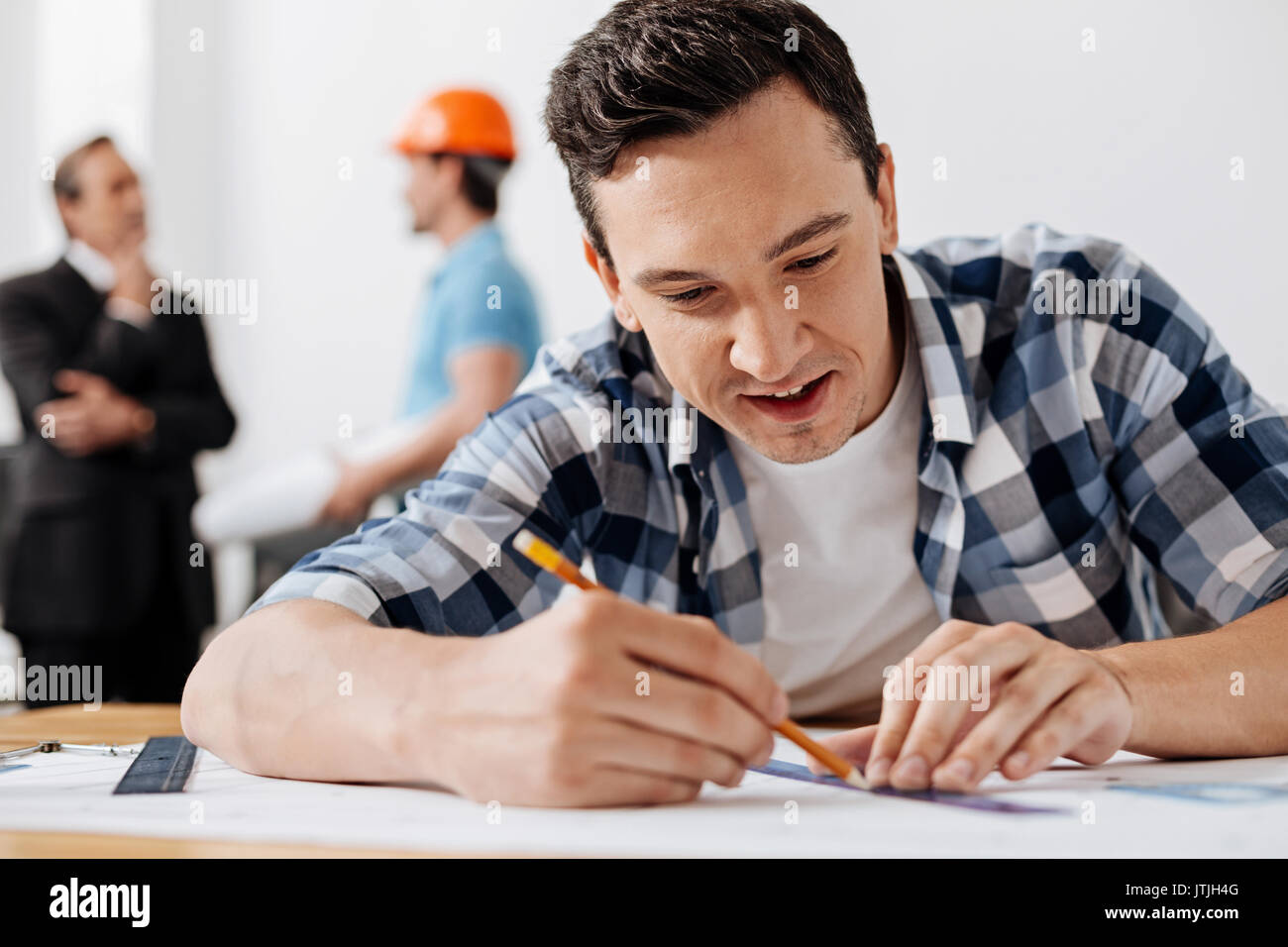Handsome architect tracing lines on a new blueprint Stock Photo - Alamy