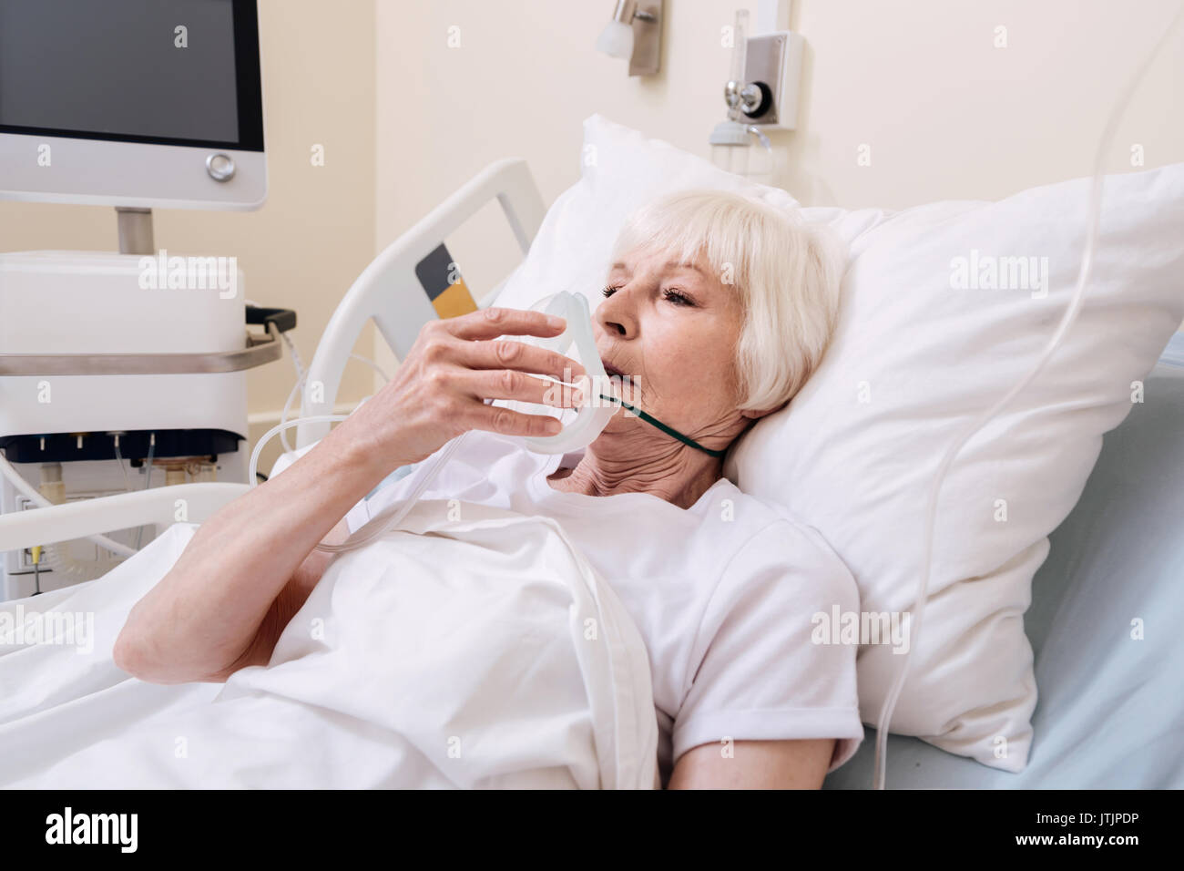 Delicate sore woman taking off her oxygen mask Stock Photo - Alamy