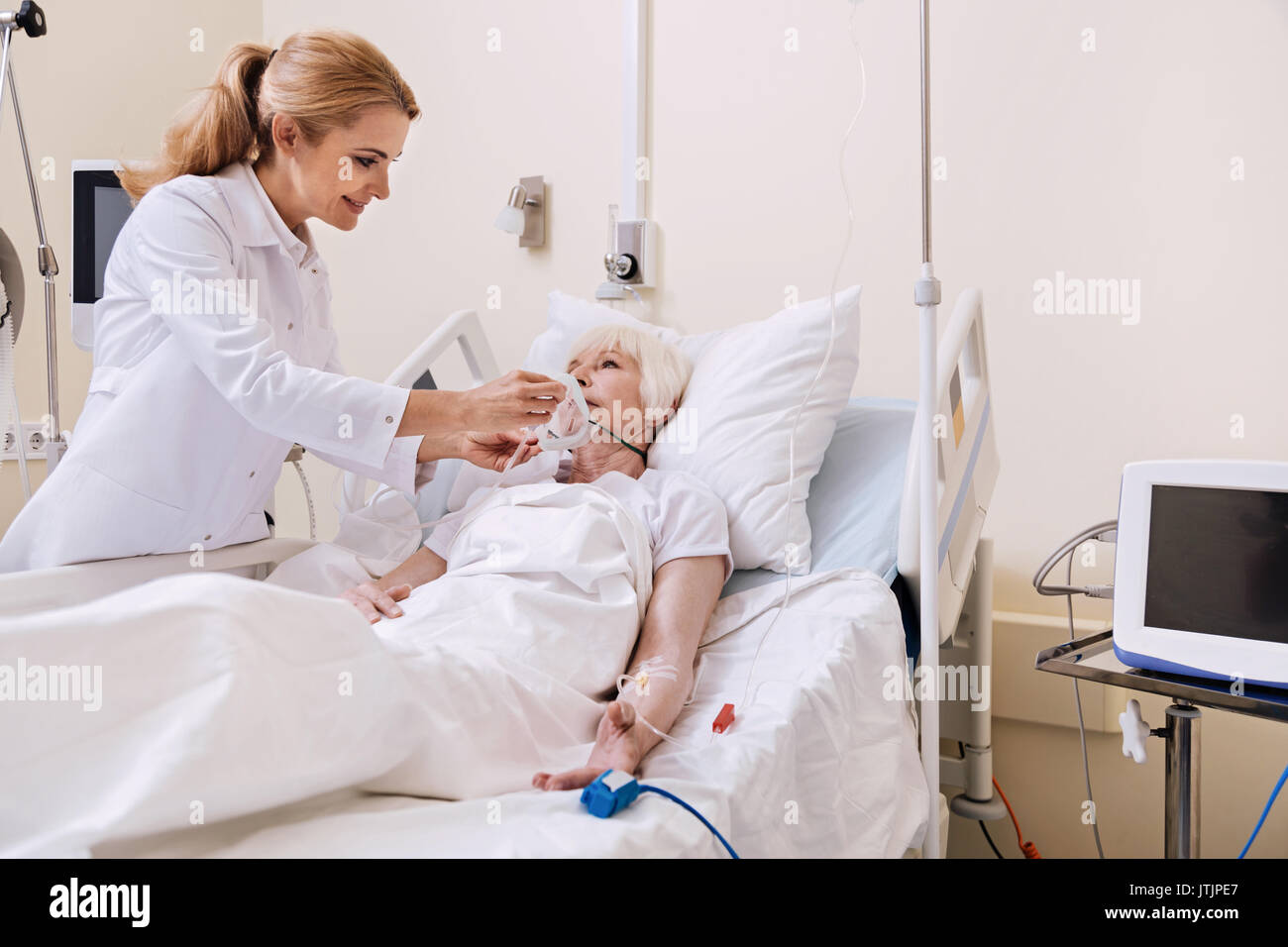 Sweet professional doctor taking care of aged patient Stock Photo - Alamy