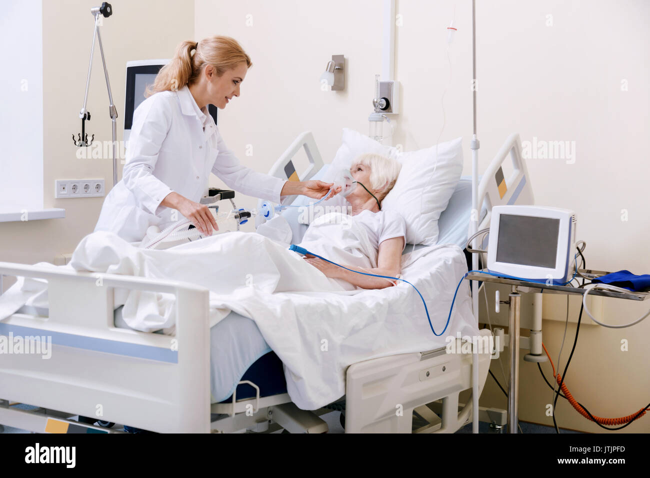 Charming trained doctor taking good care of her patient Stock Photo - Alamy