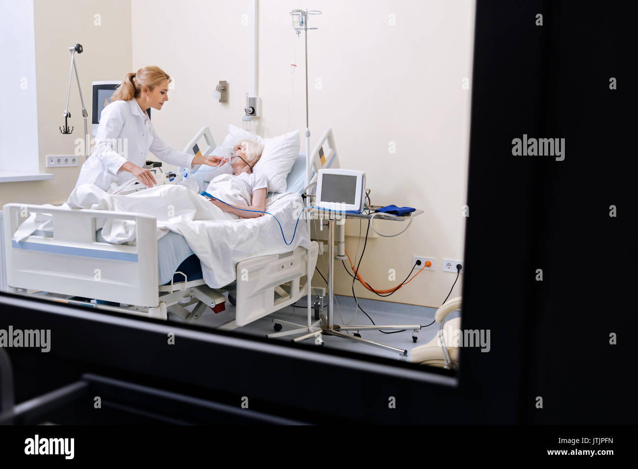 Delicate prominent doctor nursing elderly lady Stock Photo - Alamy