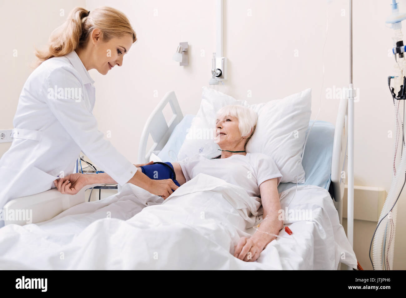 Committed clever doctor measuring blood pressure Stock Photo - Alamy