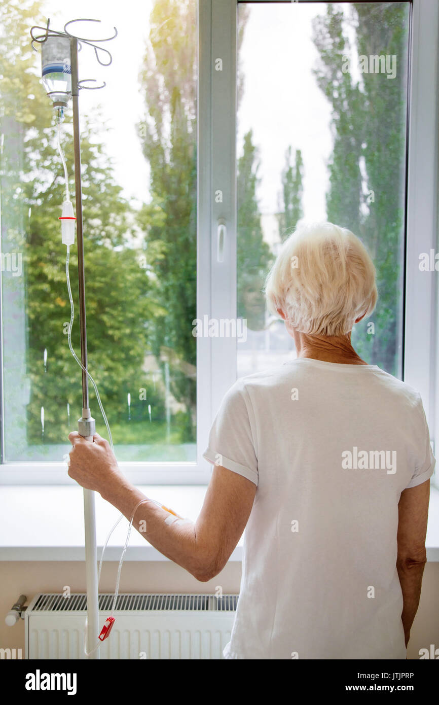 Grey haired delicate woman hoping getting better soon Stock Photo - Alamy