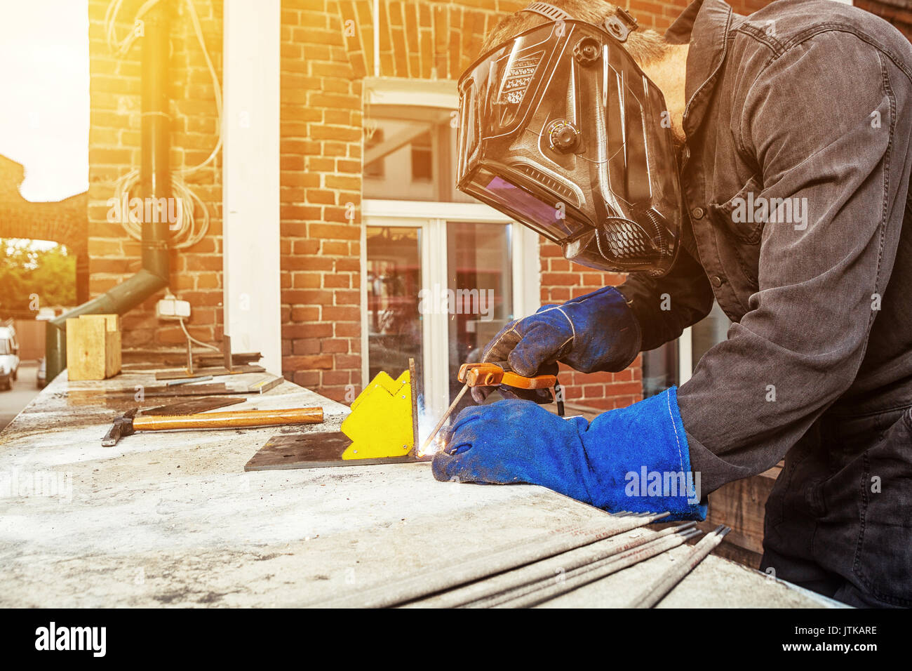 A strong man welder in a construction black overall and welding smear ...