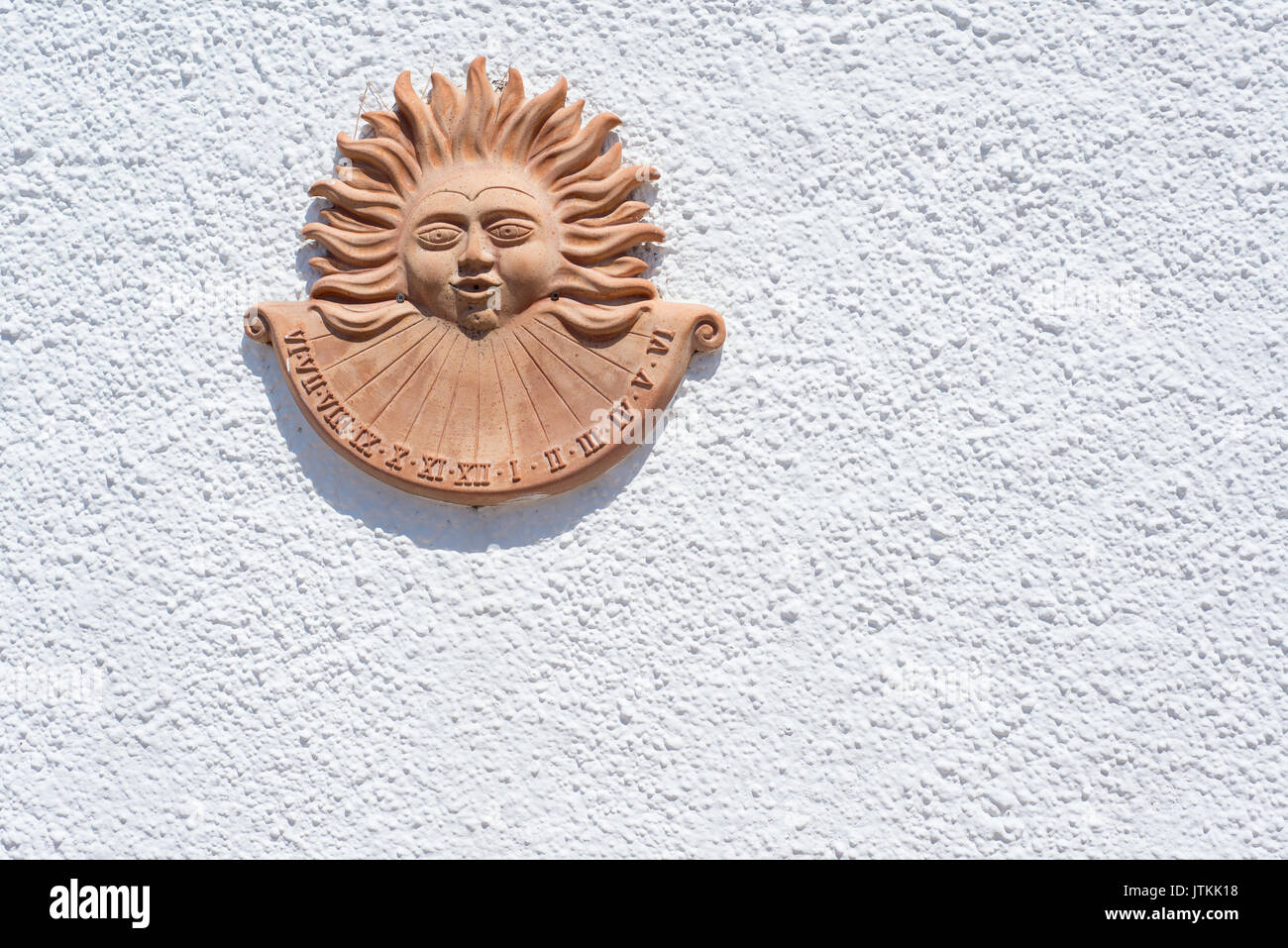 Sundial in clay pottery representing a sun on an empty white wall Stock ...