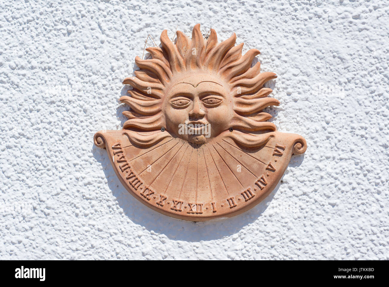 Sundial in clay pottery representing a sun on an empty white wall Stock ...