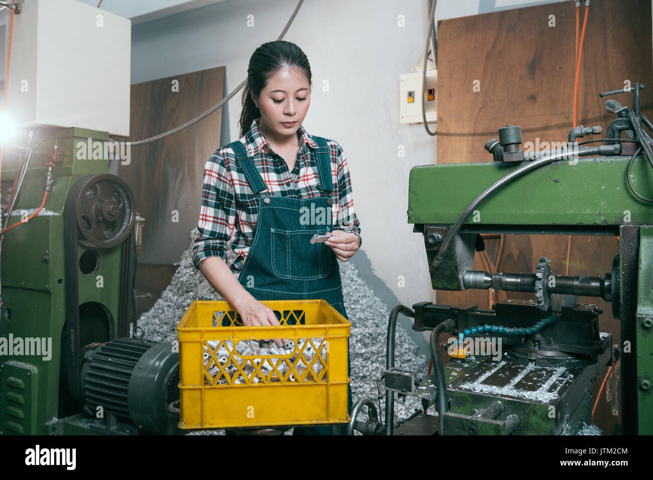 professional lathe factory female manager looking at product and ...