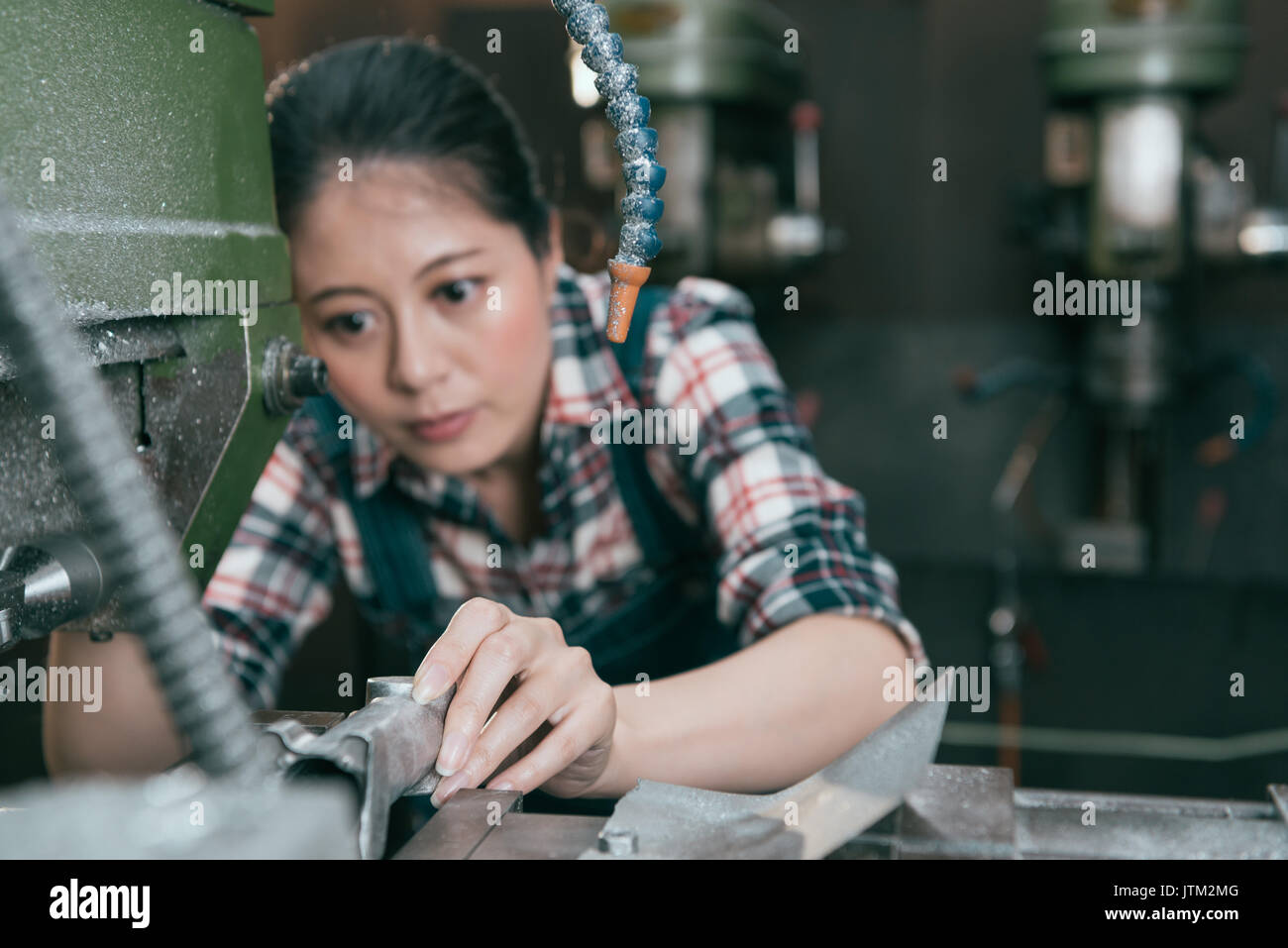 professional milling machining female employee put steel parts into ...