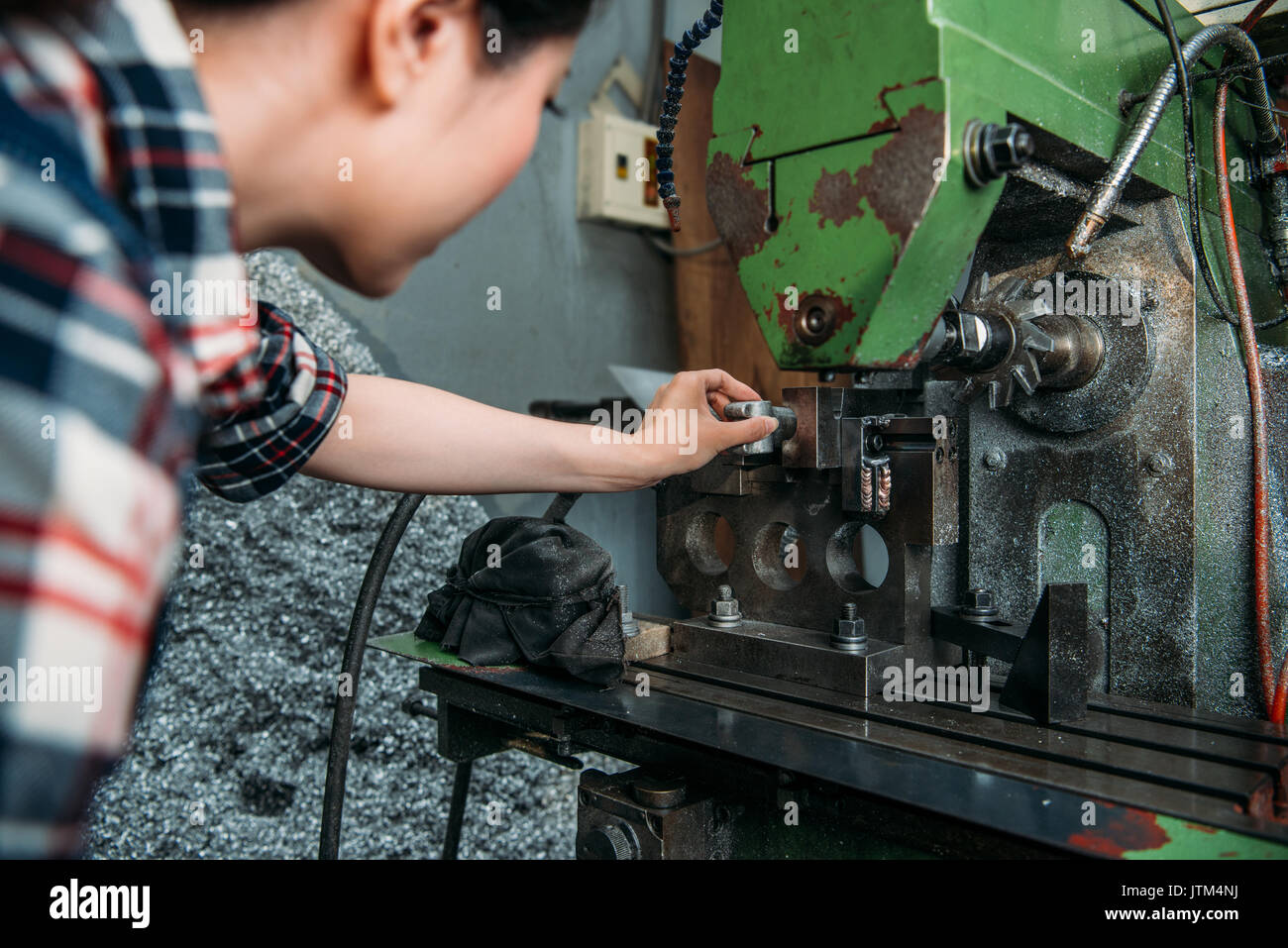 seriously milling machine female staff put finished parts into ...