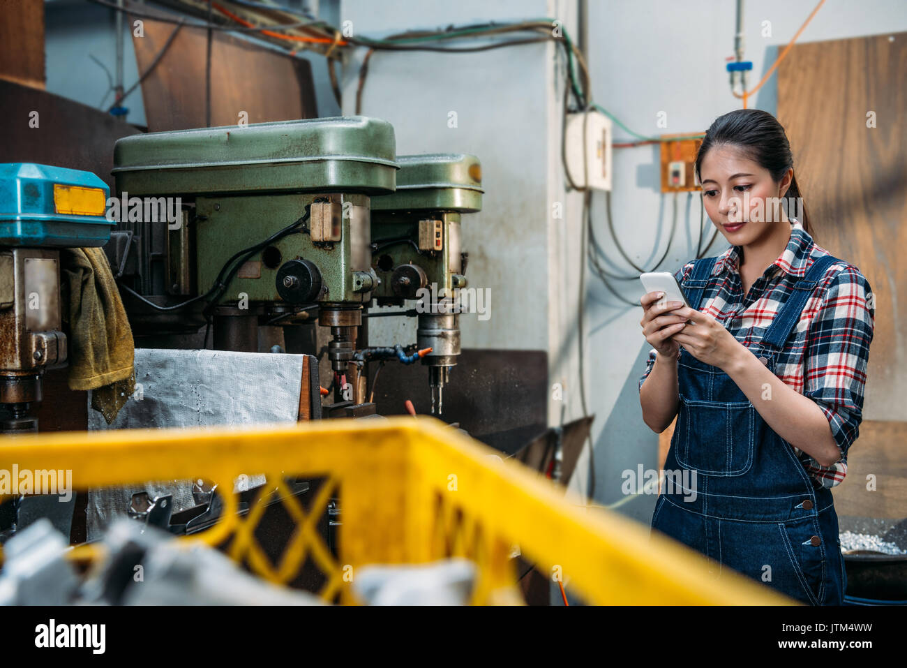 young parts factory female staff use mobile phone send message contact ...