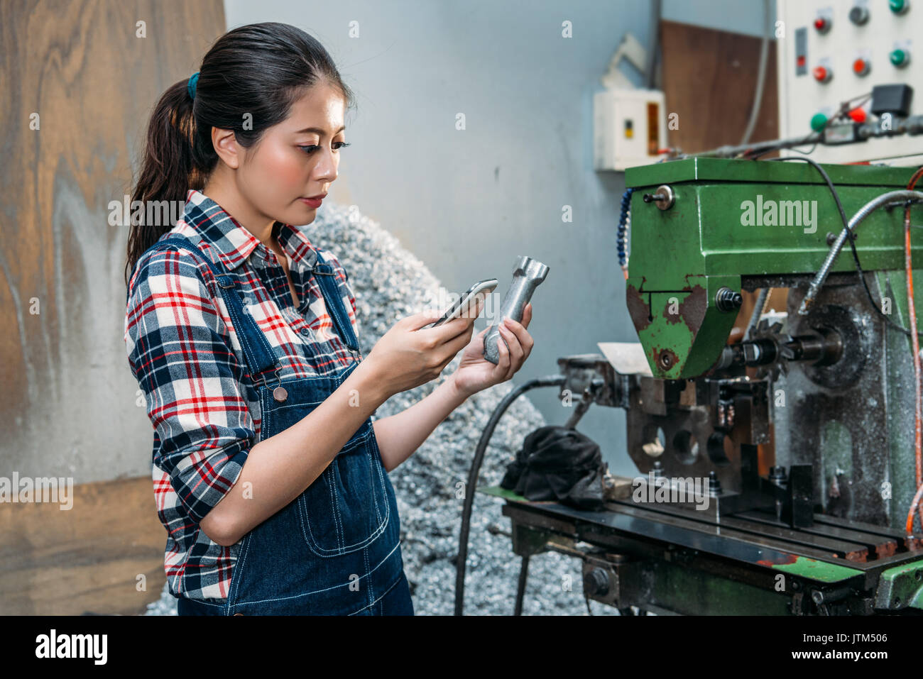 pretty milling machine female staff holding factory finished product ...