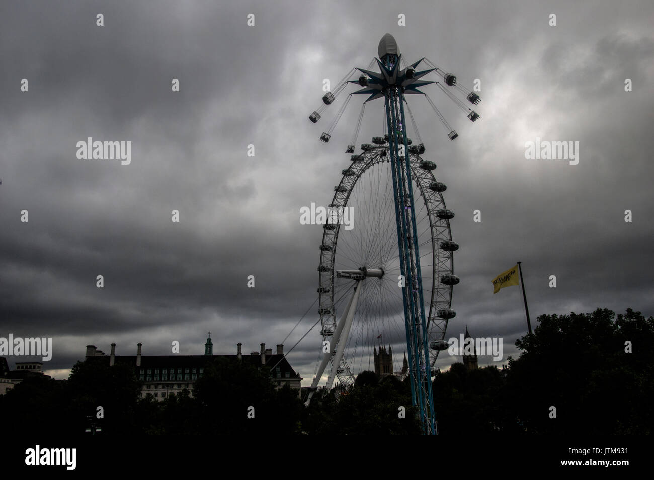 Overcast, cloudy day in London with a view of an amusement park ride ...