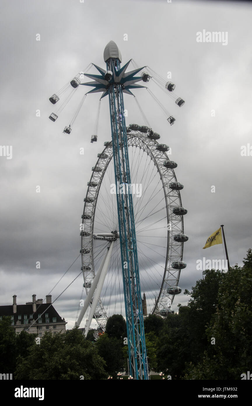 Overcast, cloudy day in London with a view of an amusement park ride ...