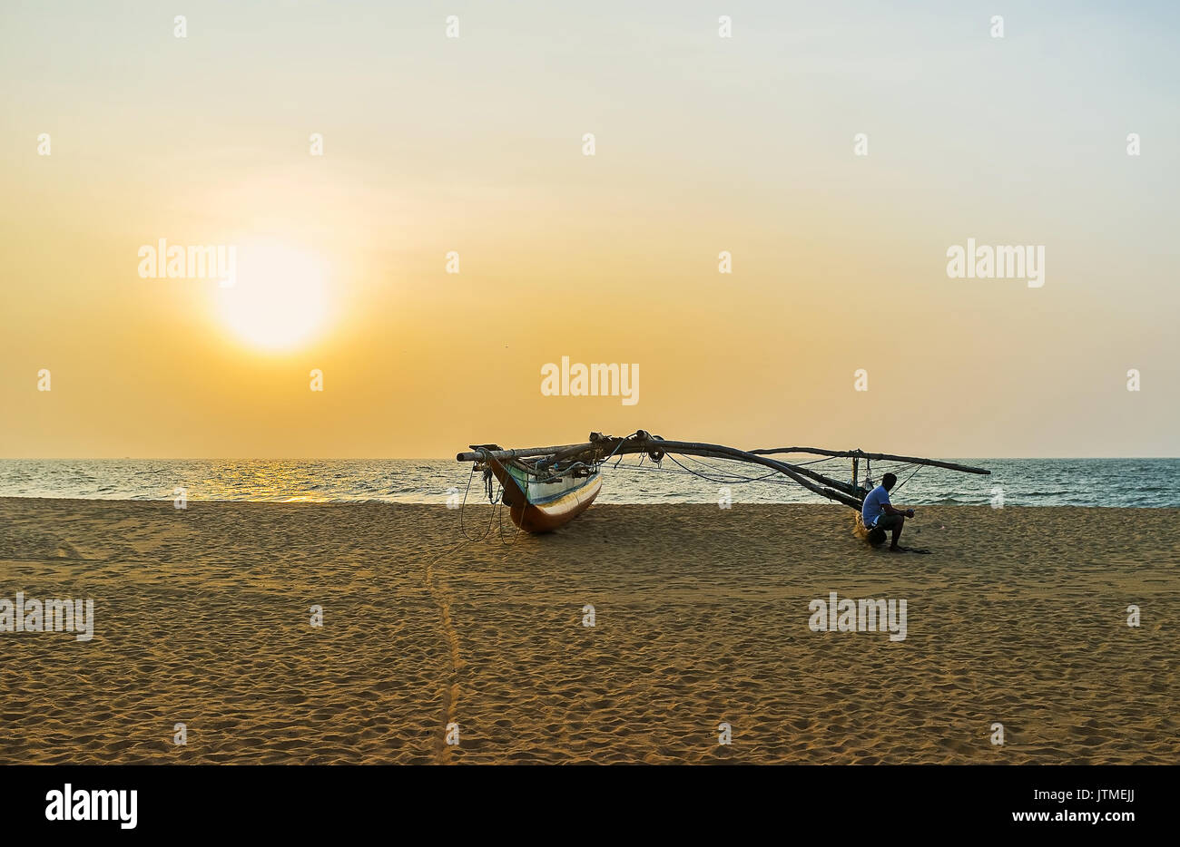 The sunset on the beach with a view on the old oruwa canoe on the sand ...
