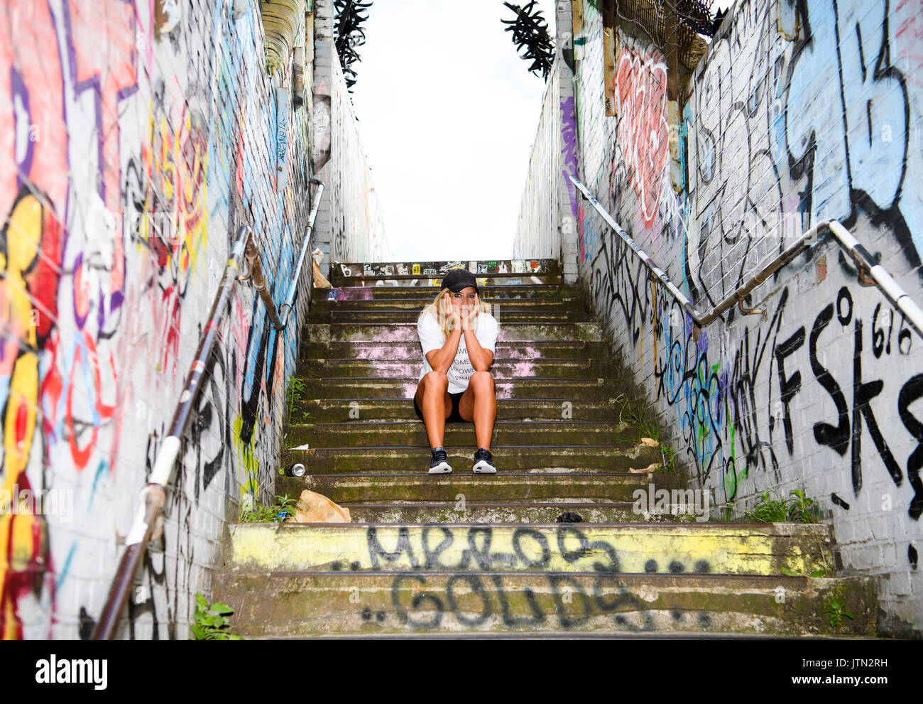 A beautiful and athletic young woman poses in front of graffiti Stock ...