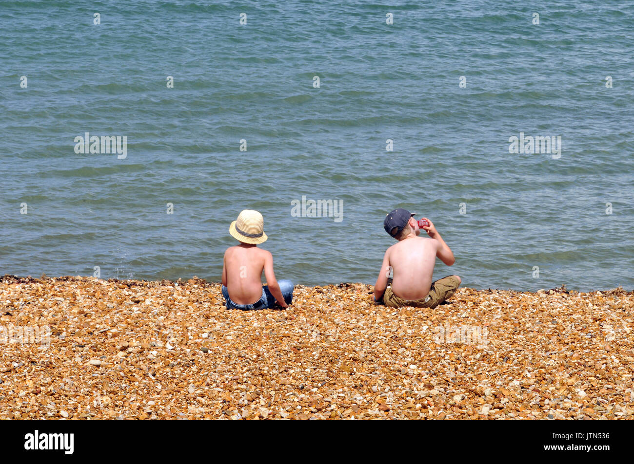 Kids sitting on beach backs hi-res stock photography and images - Alamy