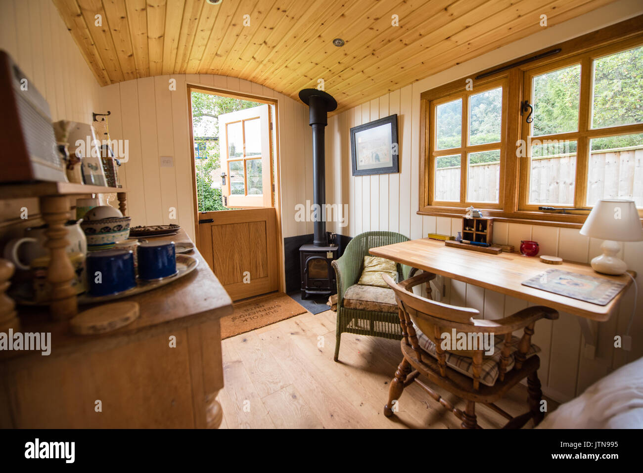 Interior of a cosy Shepherds Hut with a woodburner, bed and antique ...