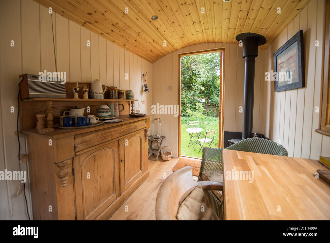 Interior of a cosy Shepherds Hut with a woodburner, bed and antique ...