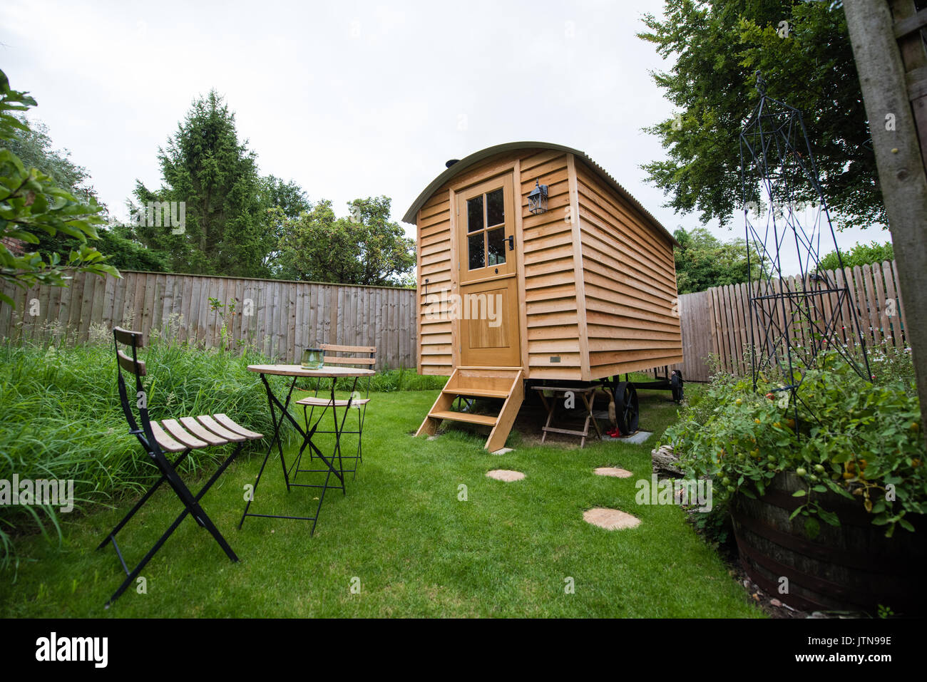 Hand built wooden shepherds' hut in a rural garden with a table and ...