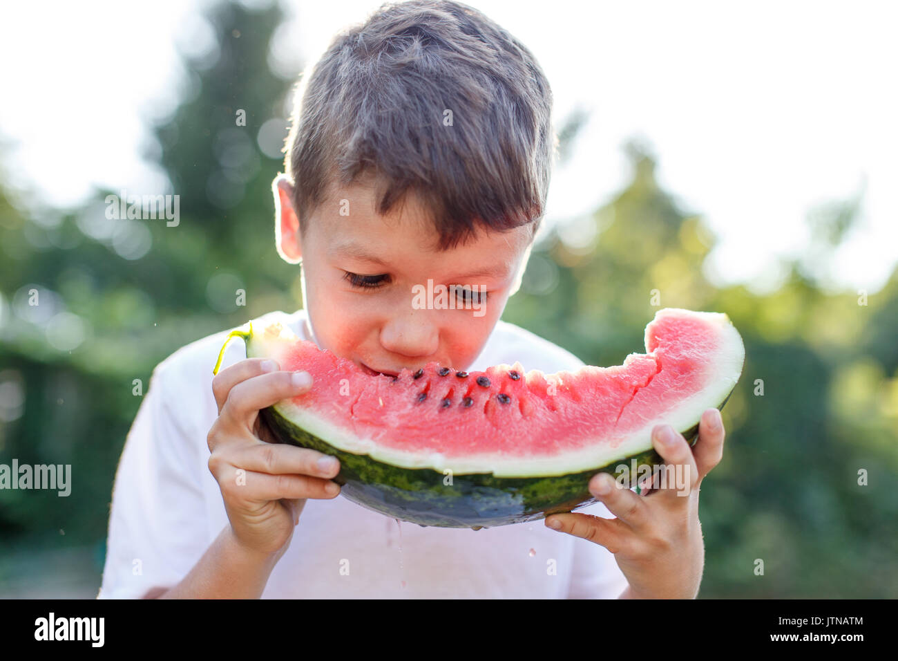 Little boy bite into watermelon with closed eyes outdoor Stock Photo ...