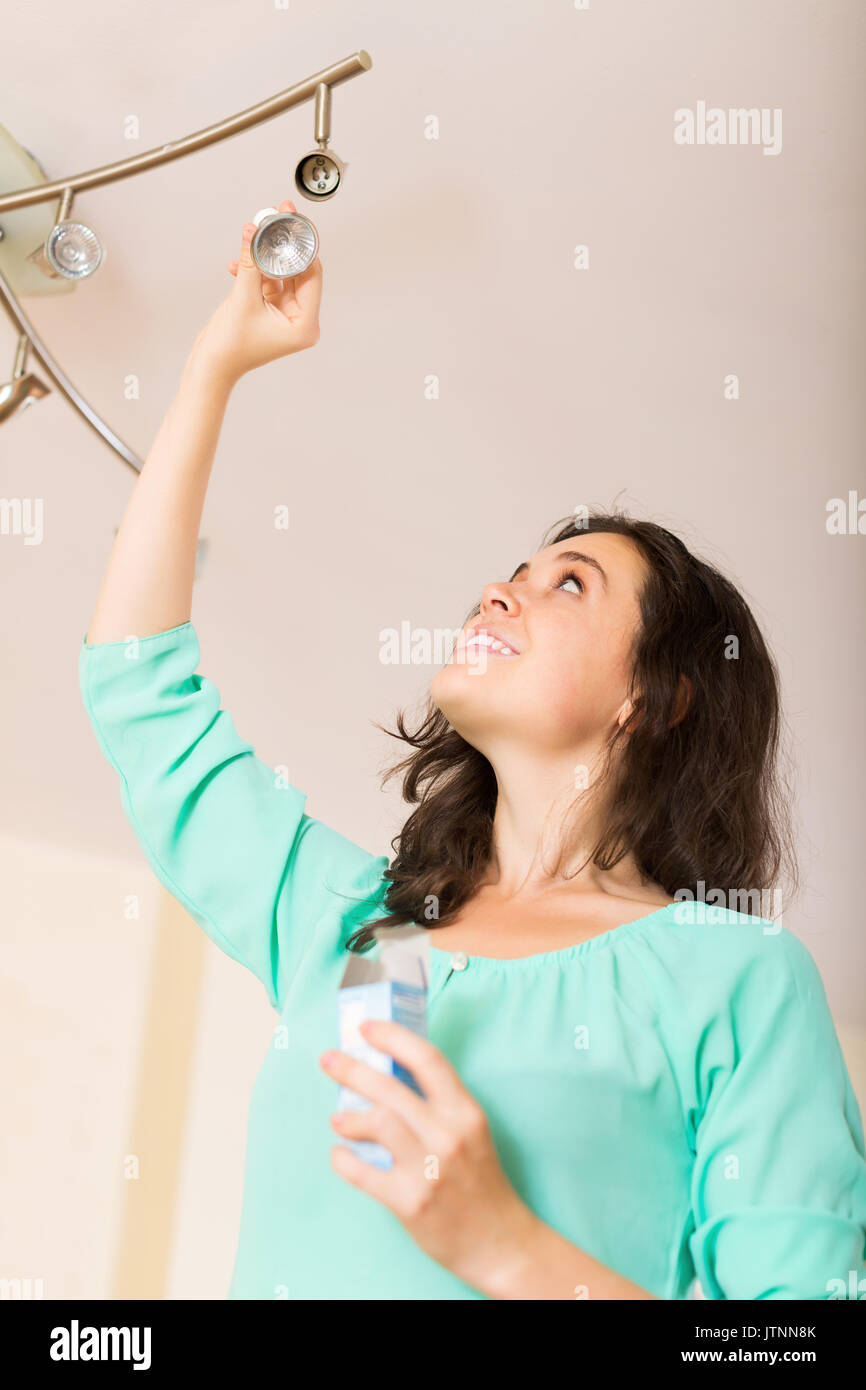 Young woman changing light bulb at her home Stock Photo - Alamy