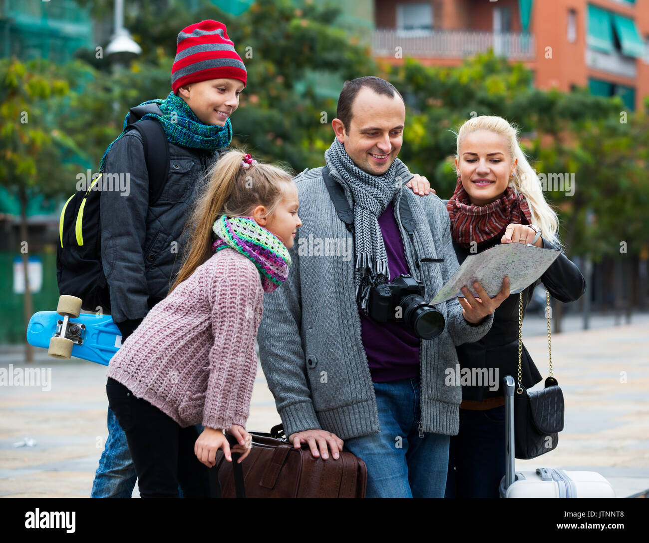 Happy middle class family of four checking the direction in a map Stock ...