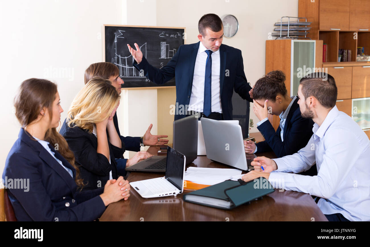Disappointed boss shouting at employees in office interior Stock Photo ...