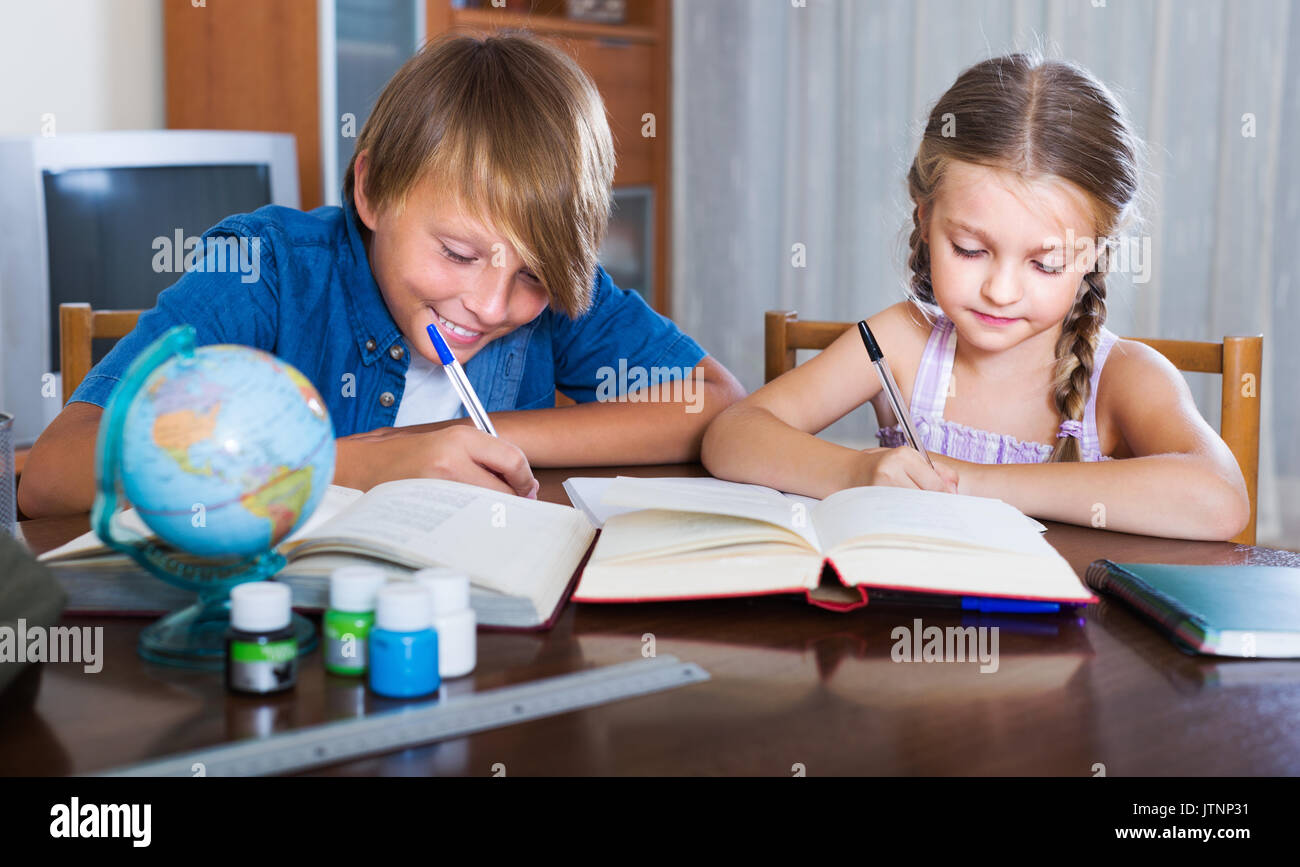 Portrait of big brother helping little girl writing homework Stock ...