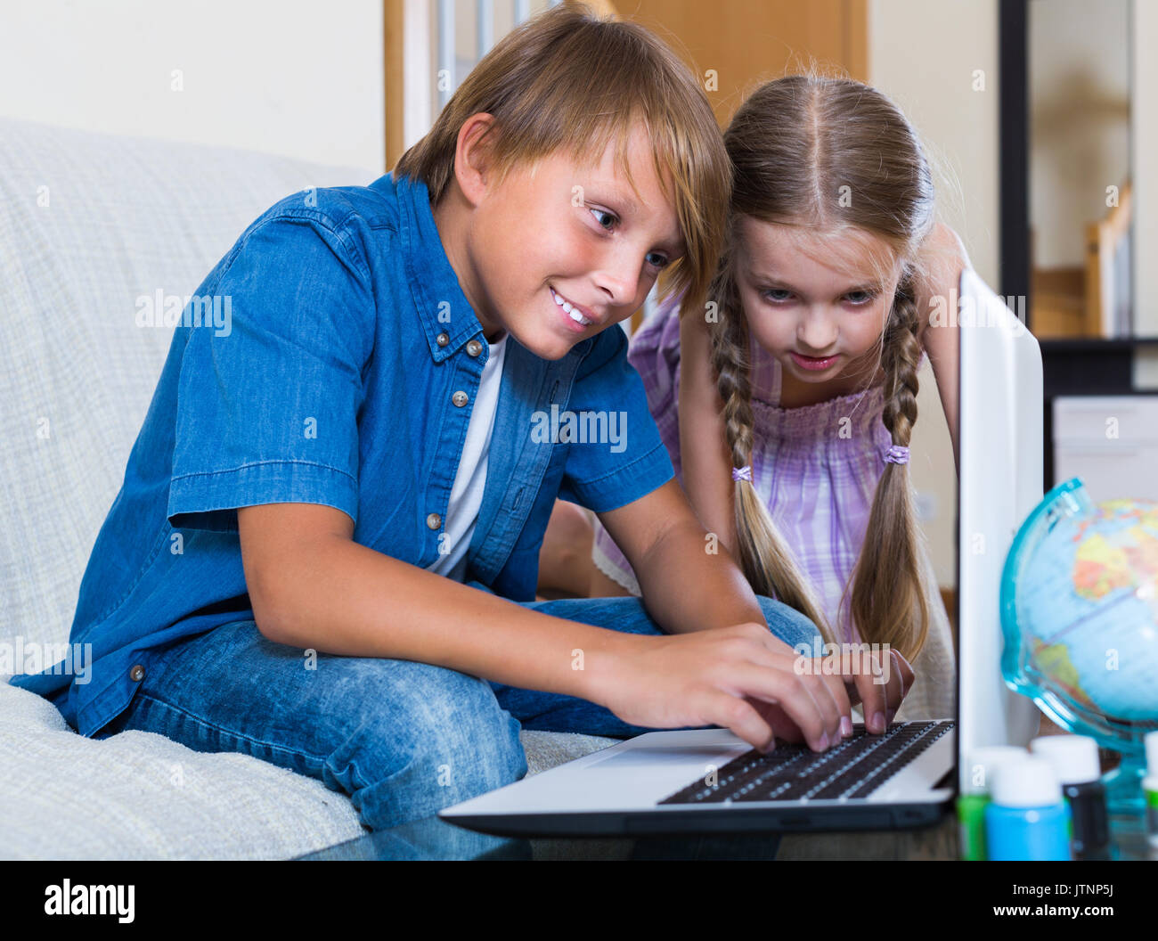 Smiling children playing computer game on laptop Stock Photo - Alamy