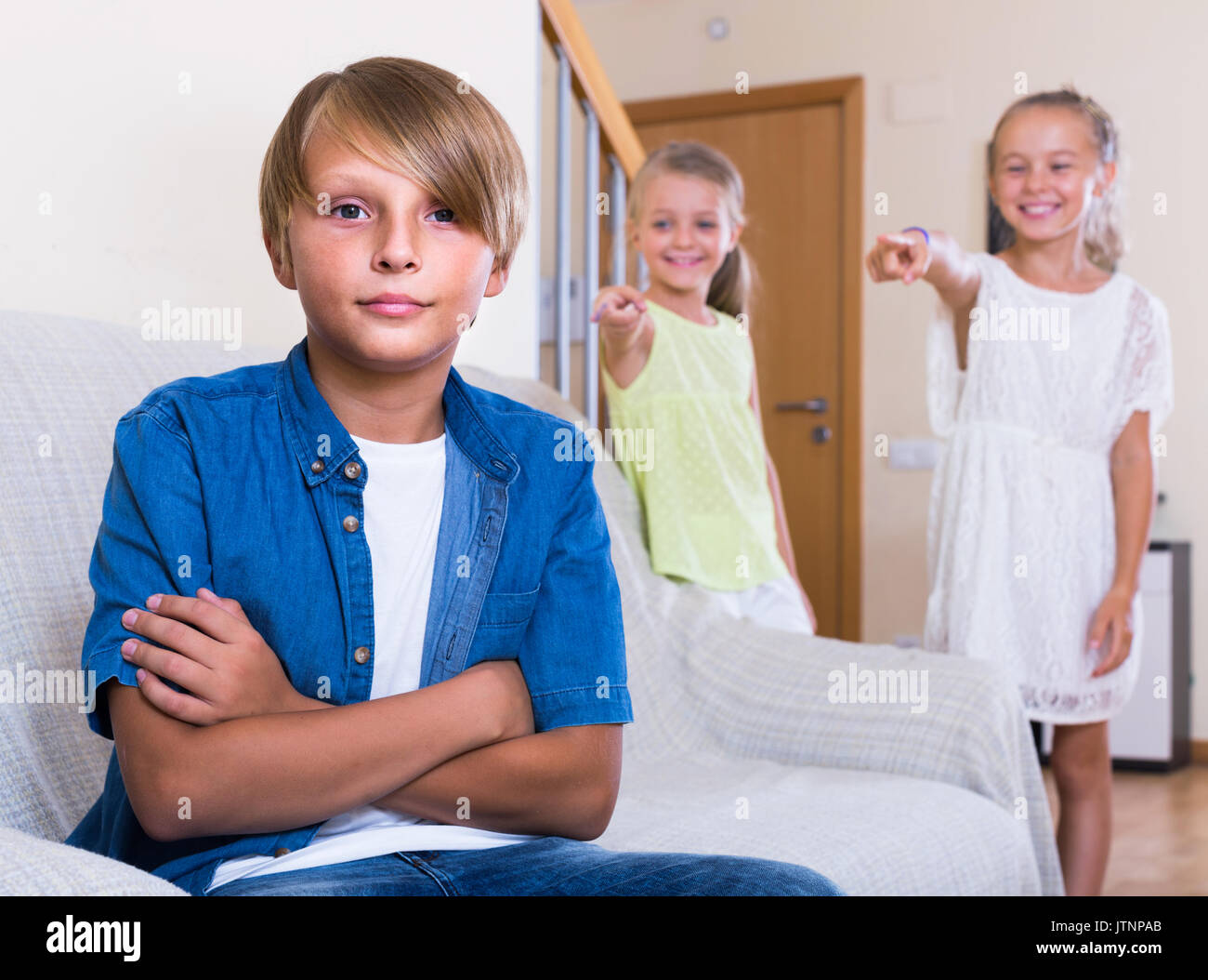 Two little girls talking and sulky spanish boy sitting separately at ...