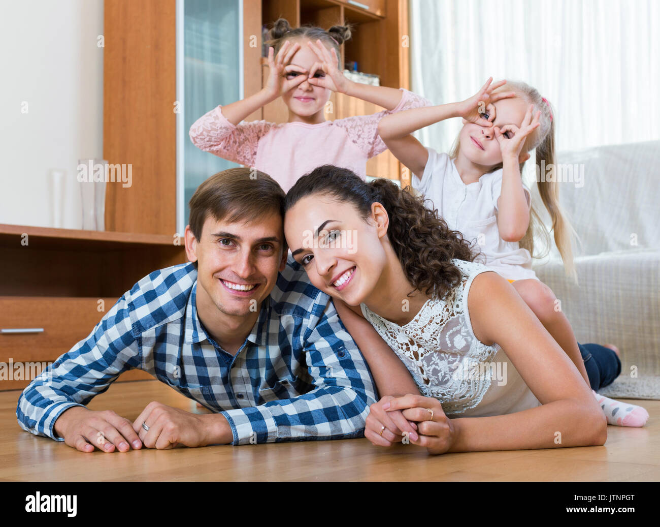 Family values: portrait of positive spanish parents with little girls ...