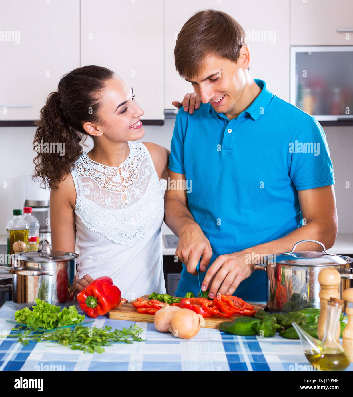 Young family couple cooking vegetables in domestic kitchen Stock Photo ...