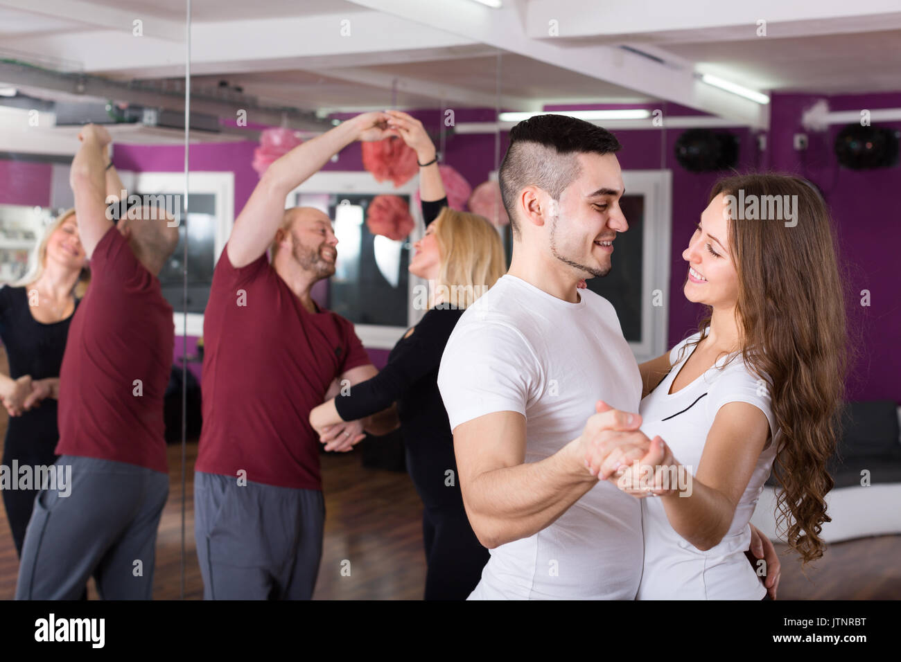 Happy young healthy people having dancing class indoors Stock Photo - Alamy