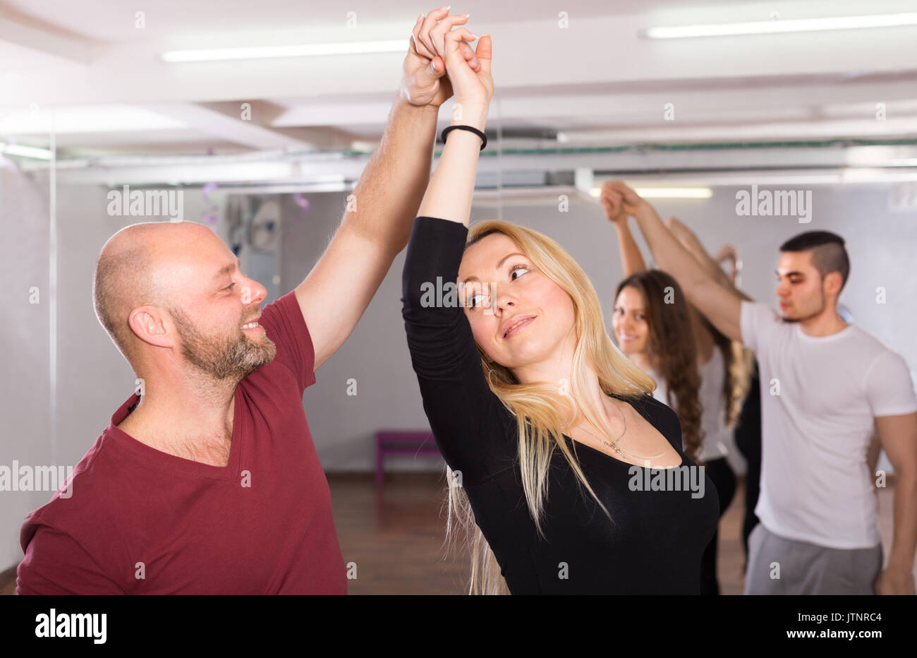 Happy 40 years old people having dancing class indoors Stock Photo - Alamy